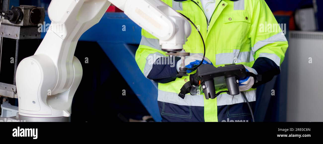 Young engineer man checking and maintenance machine robot arms ...