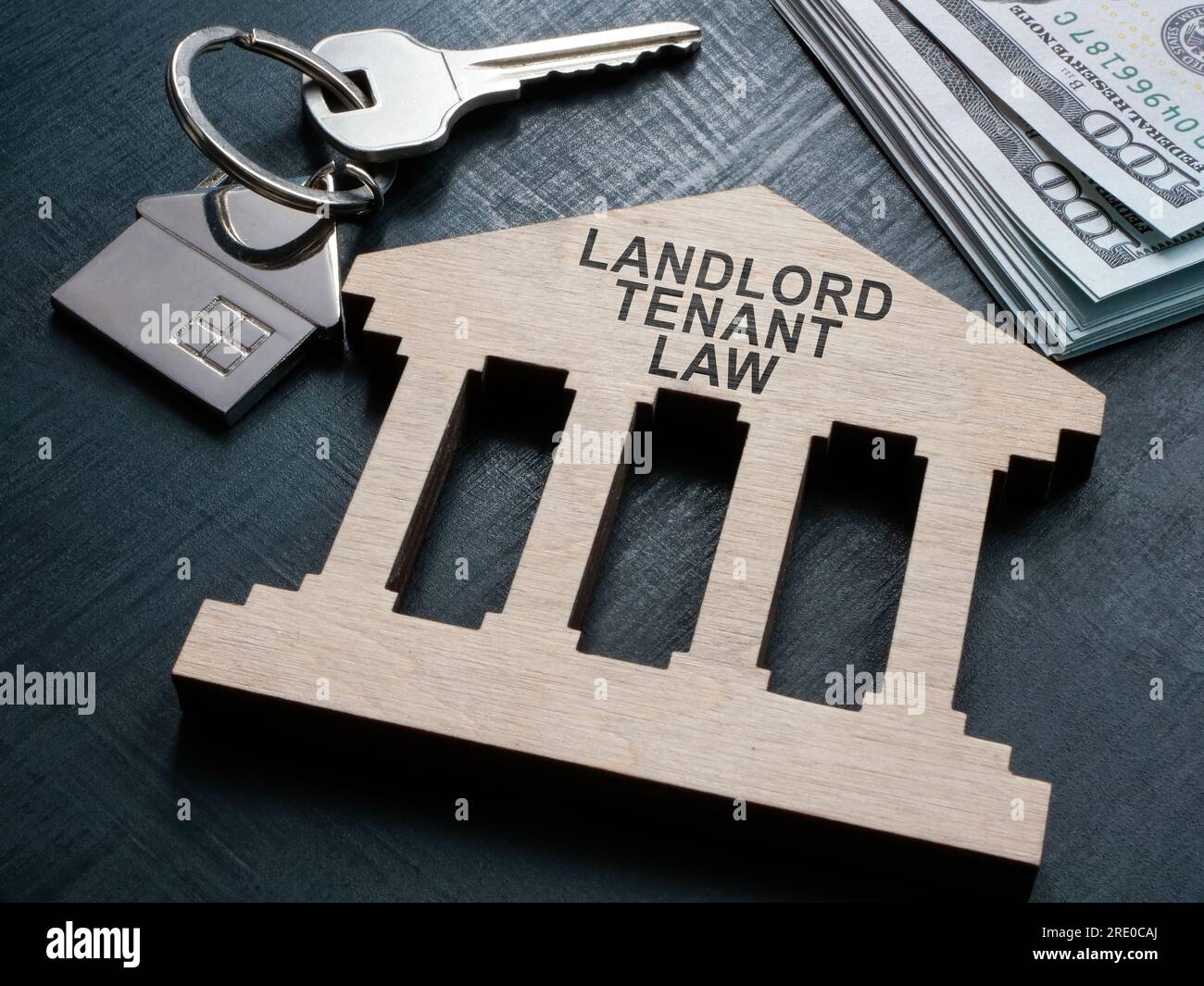 Wooden plate landlord tenant law and metal key Stock Photo - Alamy