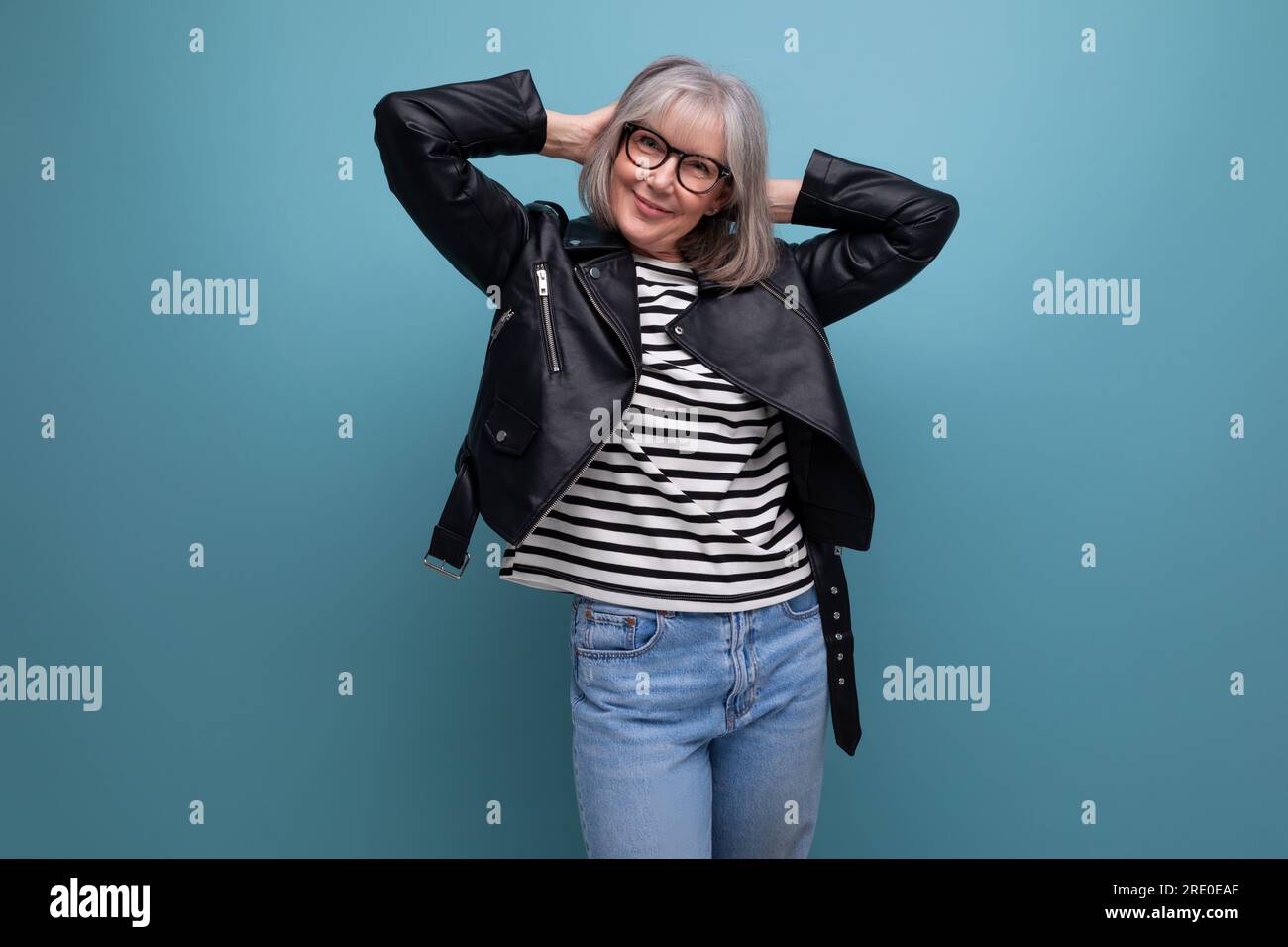 mature old woman in a stylish rocker jacket on a bright background ...