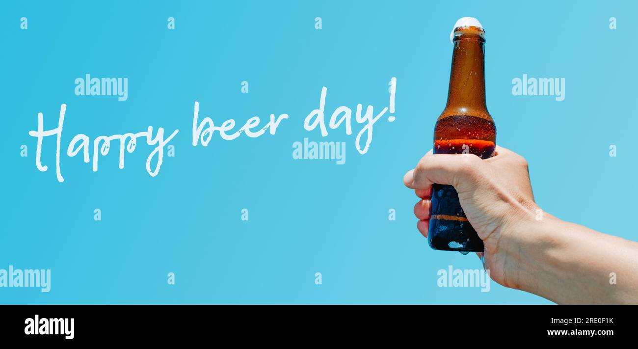 the text happy beer day and the hand of a man holding a bottle of ...