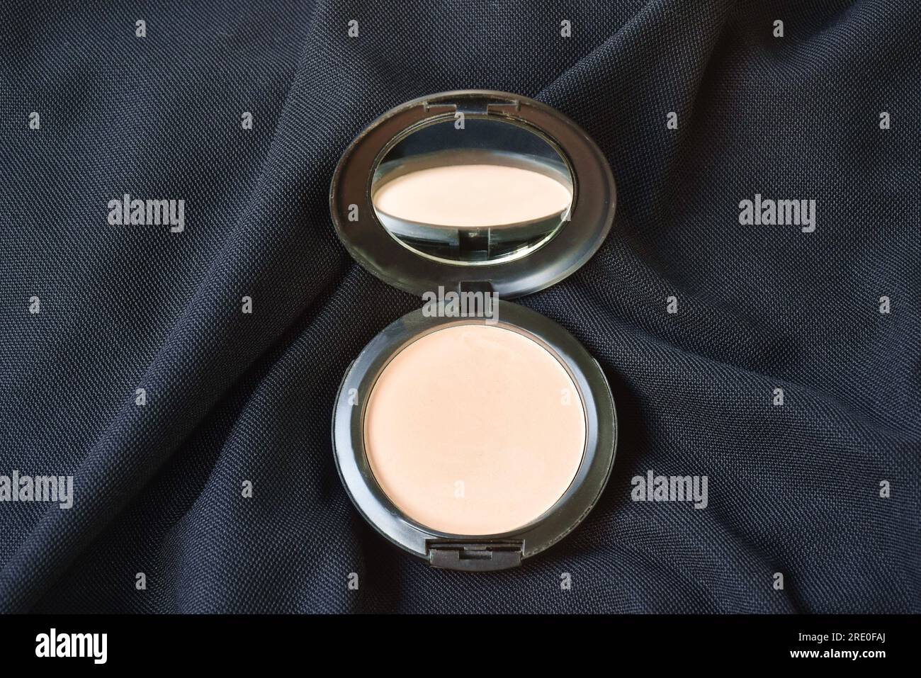 powder puff packaging with mirror on black fabric background Stock ...