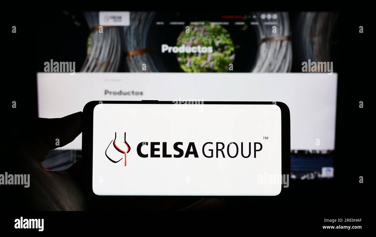 Person holding cellphone with logo of Spanish steel company CELSA Group on screen in front of ...