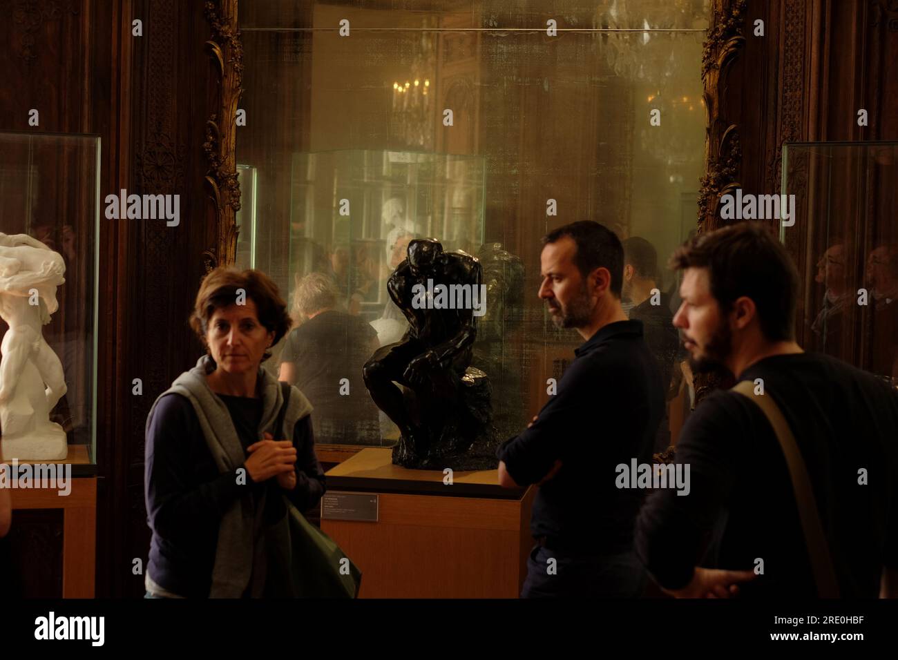 A woman, two men in profile, a small bronze sculpture of The Thinker ...