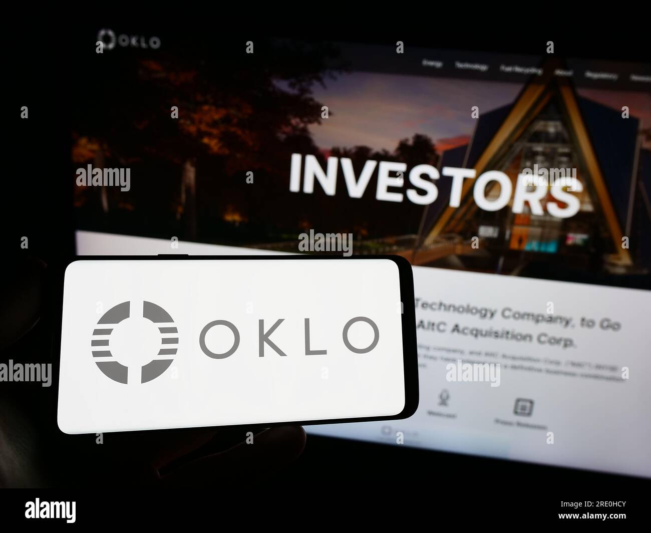 Person holding mobile phone with logo of American fission reactor company Oklo Inc. on screen in ...