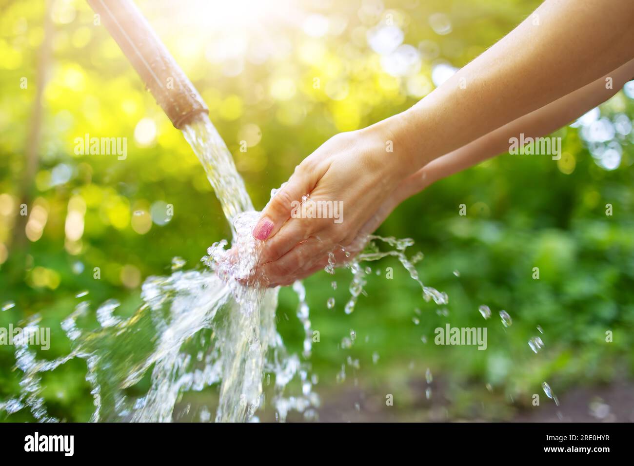 Close up view of woman's hands in natural source of water in the park ...