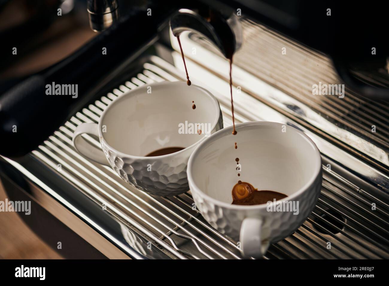 coffee extraction, hot beverage, espresso dripping into cups ...