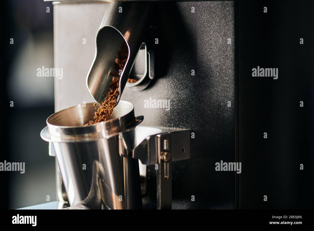 cafe equipment, ground coffee pouring from electric coffee grinder into ...