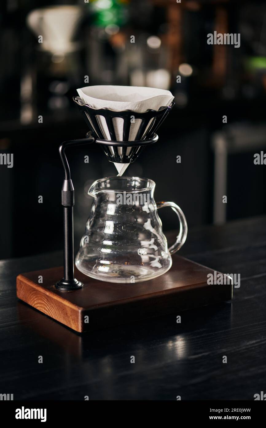 drip holder with filter bag, glass coffee pot on black wooden counter ...