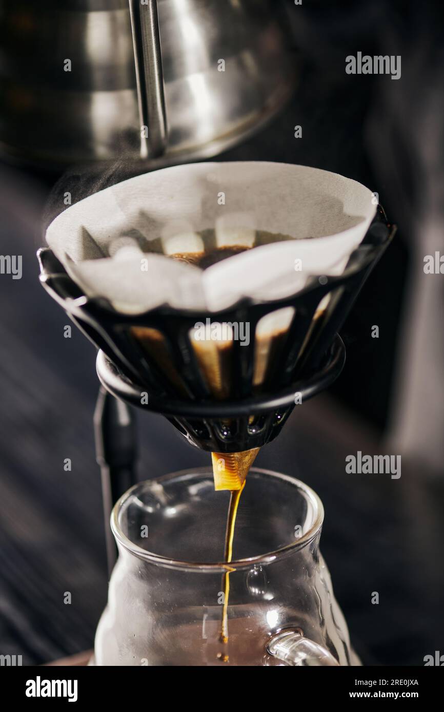 fresh espresso dripping in glass coffee pot from paper filter in ...