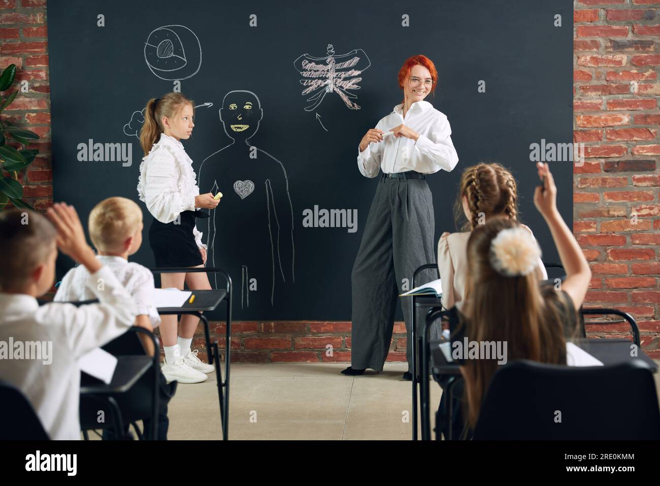 Teacher of primary school teaching to kids anatomy in classroom ...