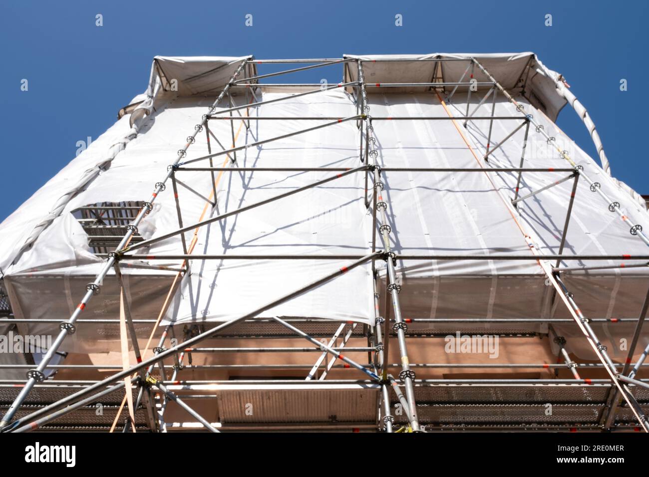 Scaffolding with protective cloth around a building to prevent ...