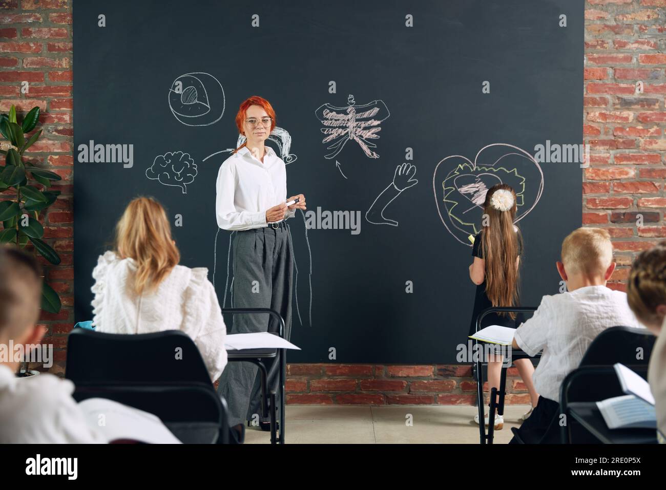 Young woman, teacher teaching anatomy to children in primary school ... Young woman, teacher teaching anatomy to children in primary school ...