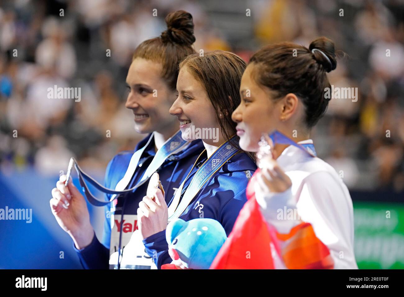 Gold medalist Kate Douglass of United States, center, is flanked by ...