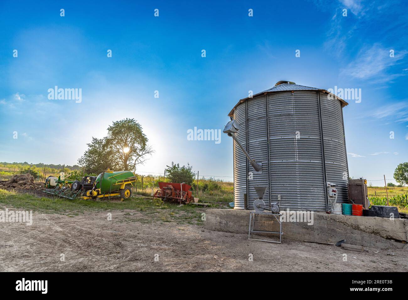 Large storage silo surrounded by vintage farm equipment Stock Photo - Alamy