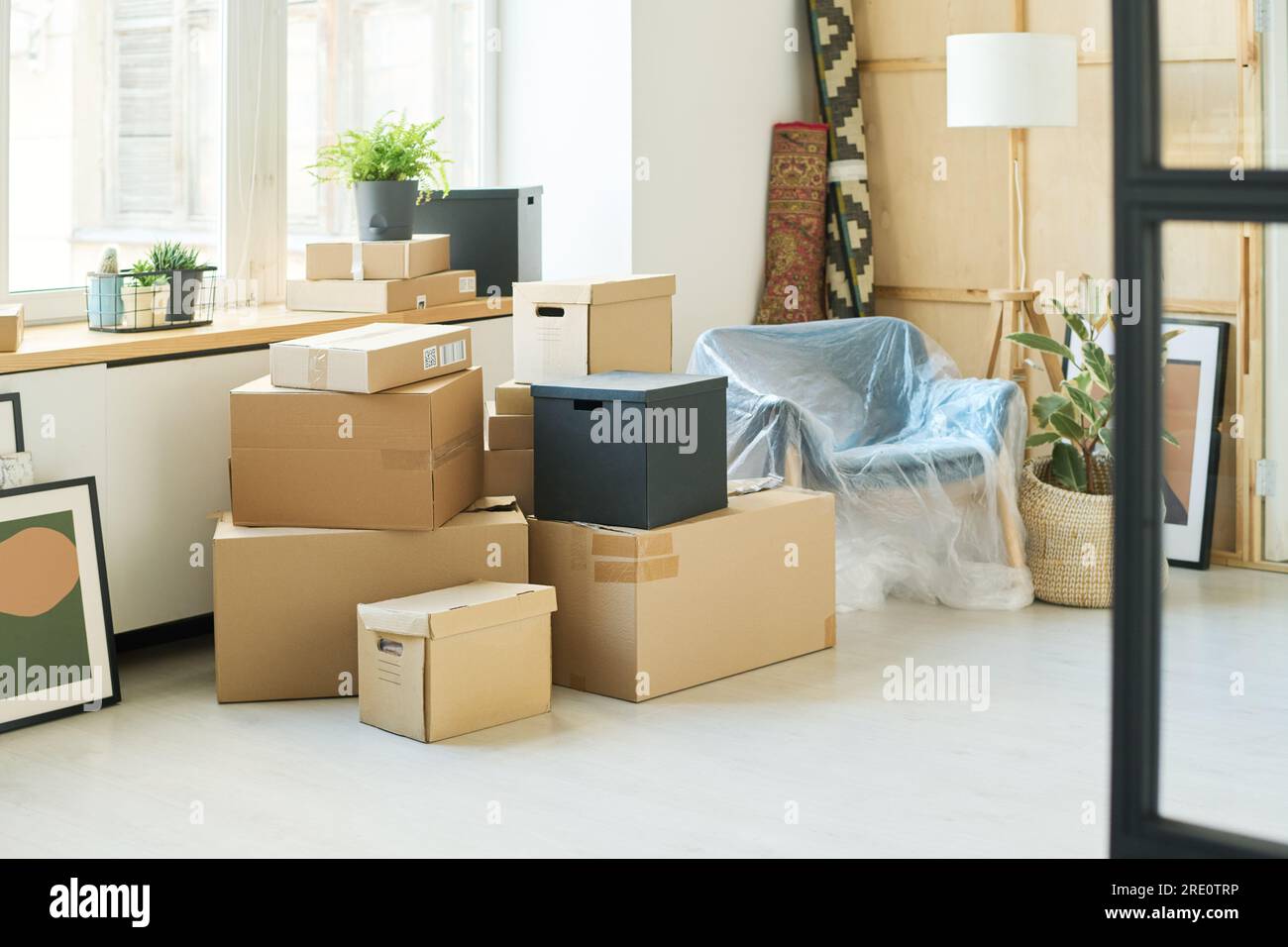 Stacks of packed cardboard boxes standing on the floor by windowsill ...