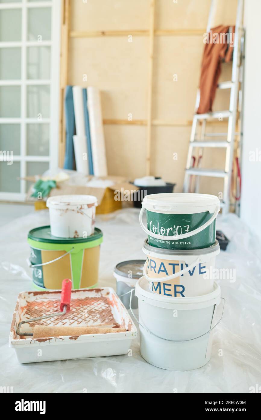 Two stacks of plastic buckets containing paints for walls and ...