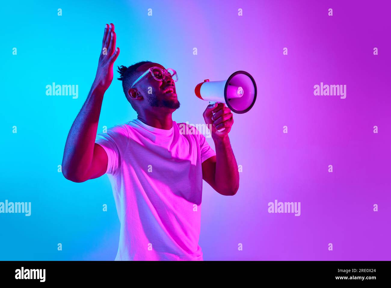 Studio photoshoot of african man shouting in megaphone and holding ...