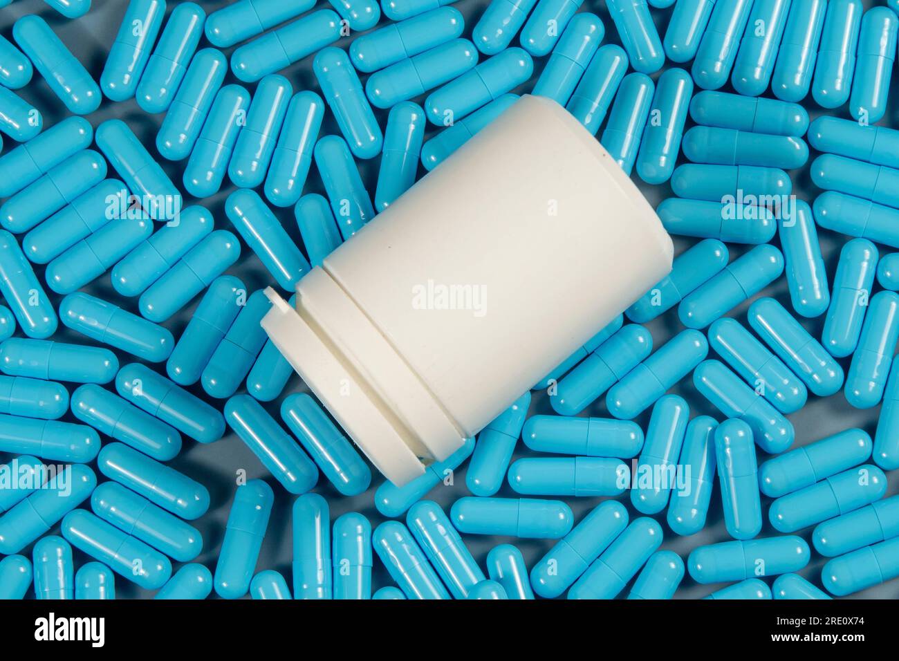 Blue antibiotic capsule pills texture with white bottle. Pharmaceutical ...