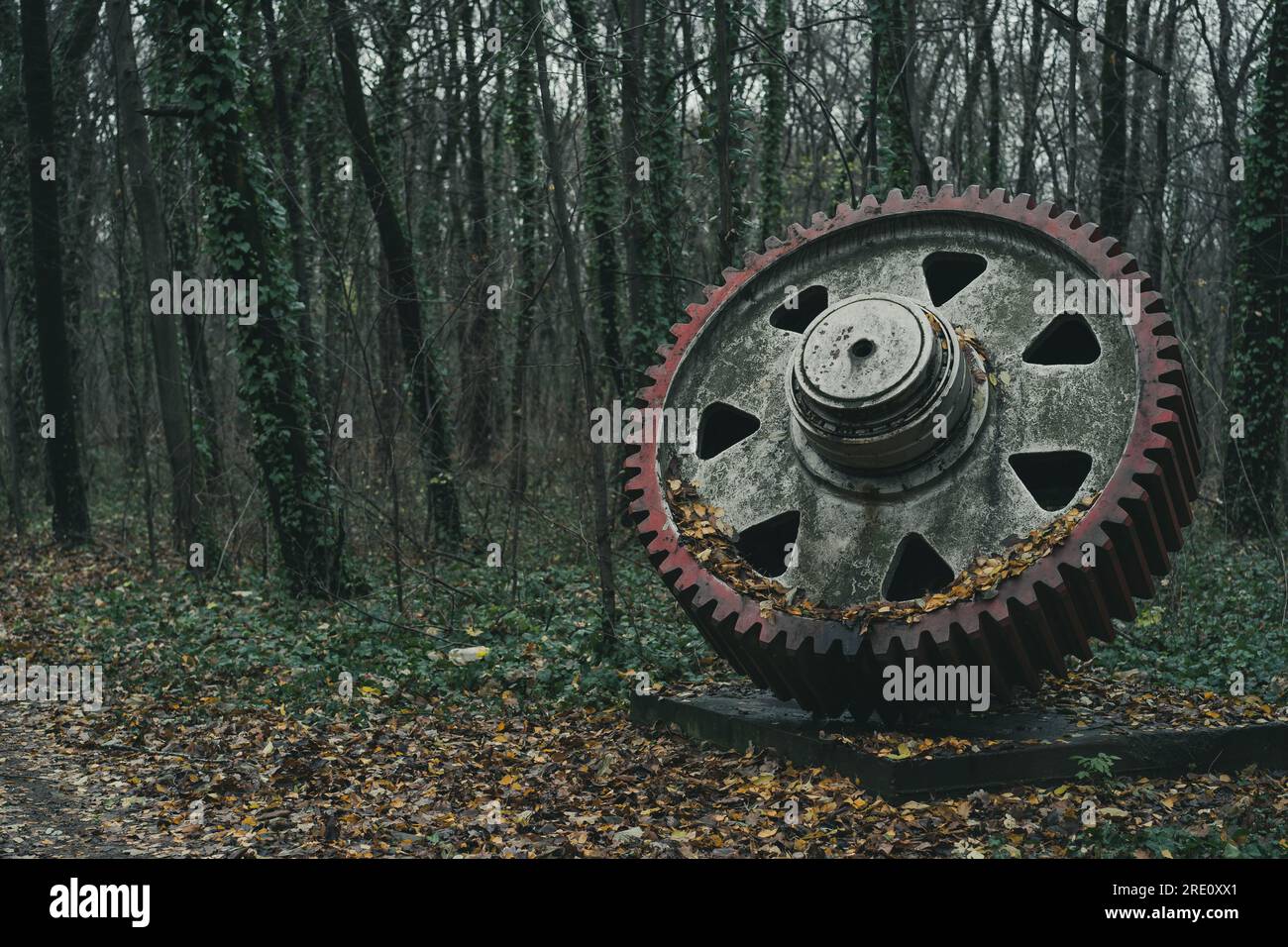 An old unused huge gear in the forest in autumn. Industrial history ...