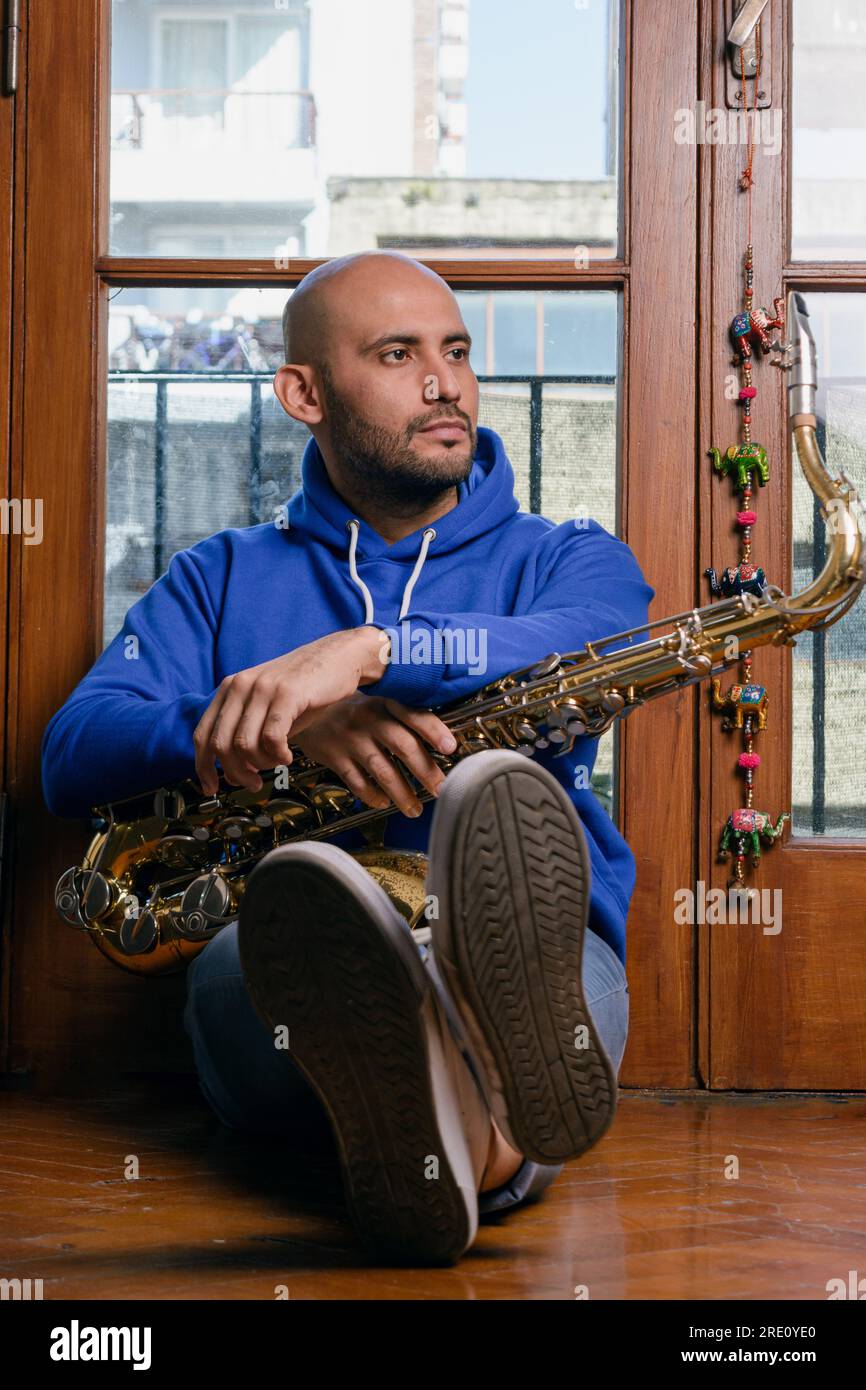 vertical portrait of young bald bearded latino saxophonist player ...