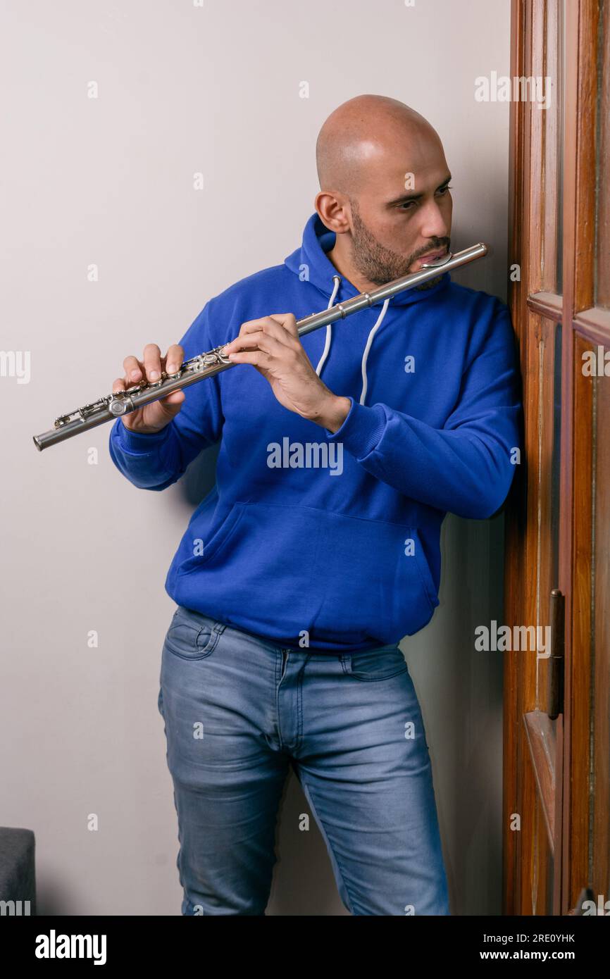 young latino young man in blue, inspired and melancholic playing the ...