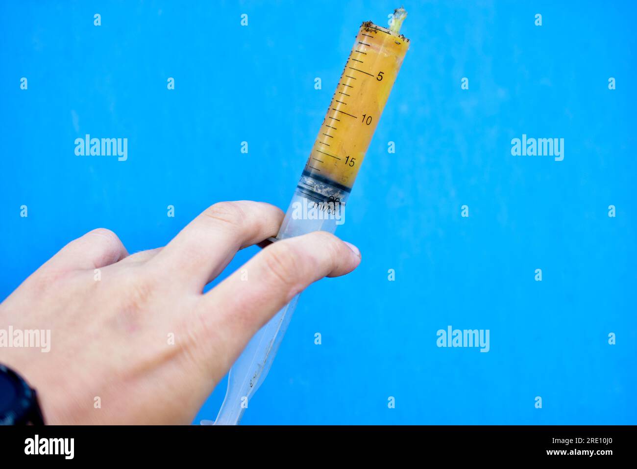 Lubricants in a syringe in your hand on a blue background Stock Photo ...