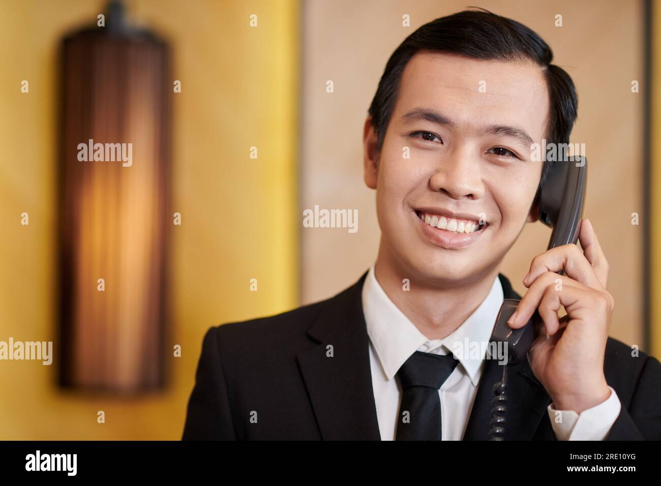 Spa resort manager talking on phone with guest and staff Stock Photo ...