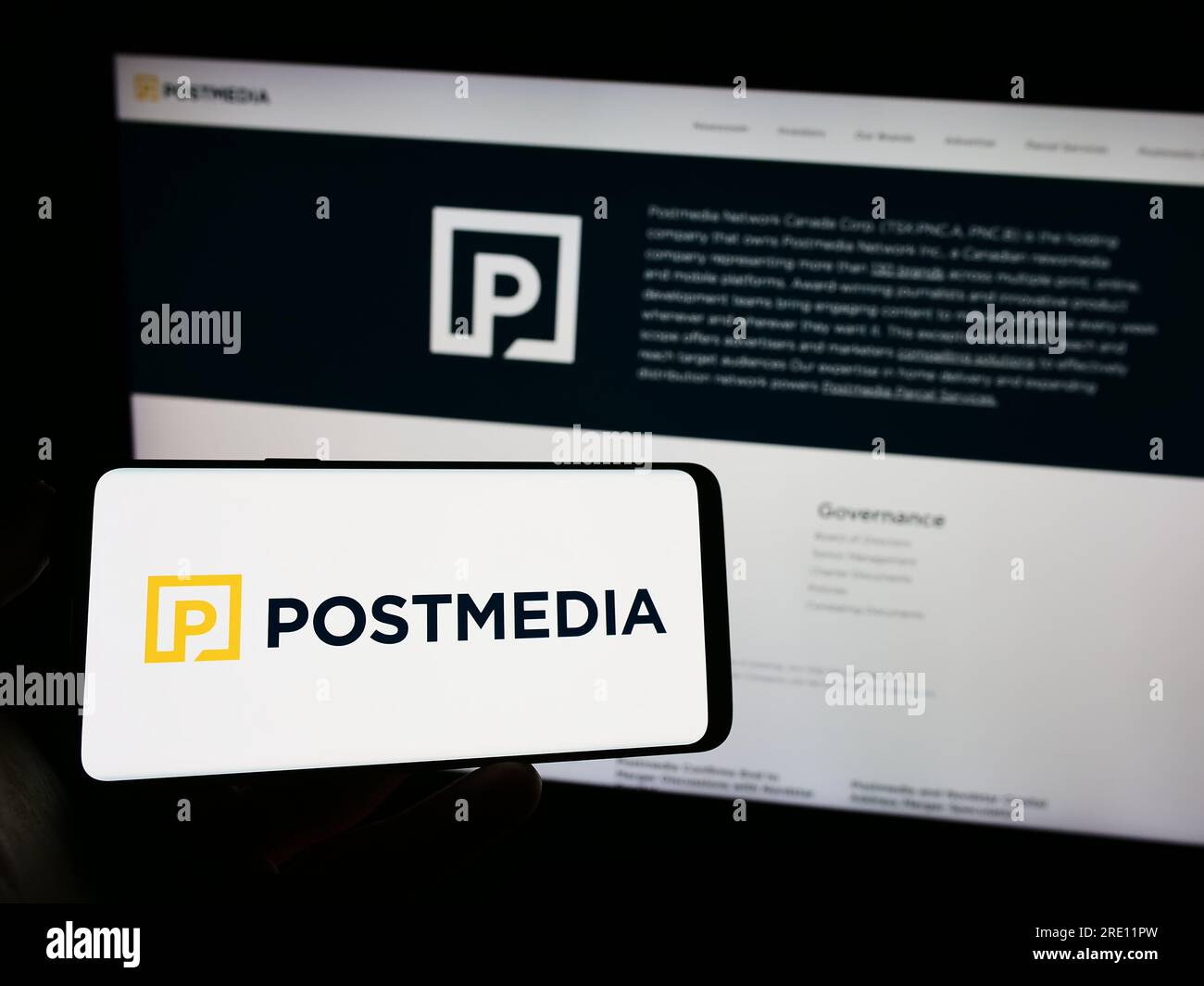 Person holding mobile phone with logo of media company Postmedia ...