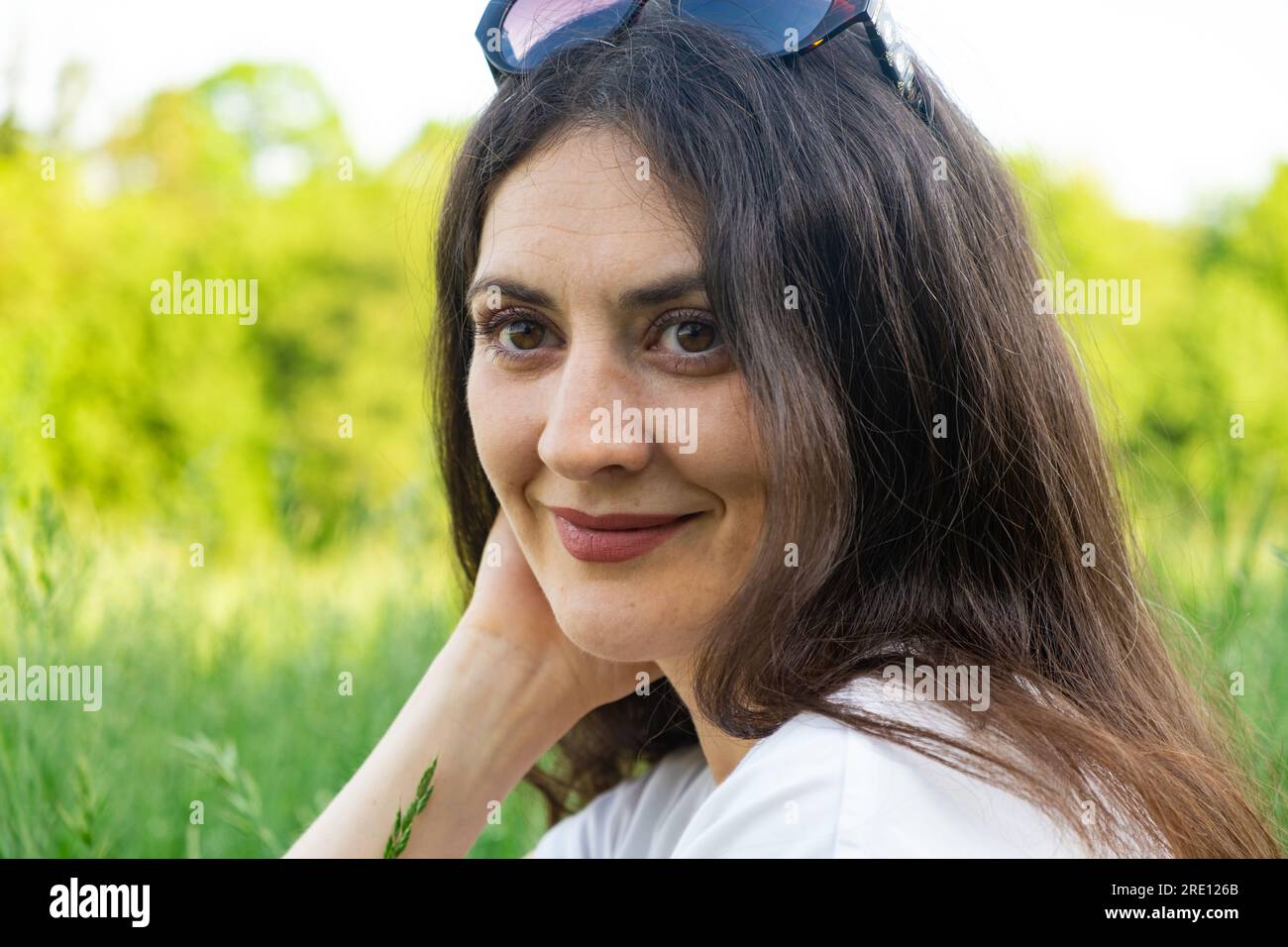 Portrait of a 35-year-old brunette woman looking at the camera smiling ...