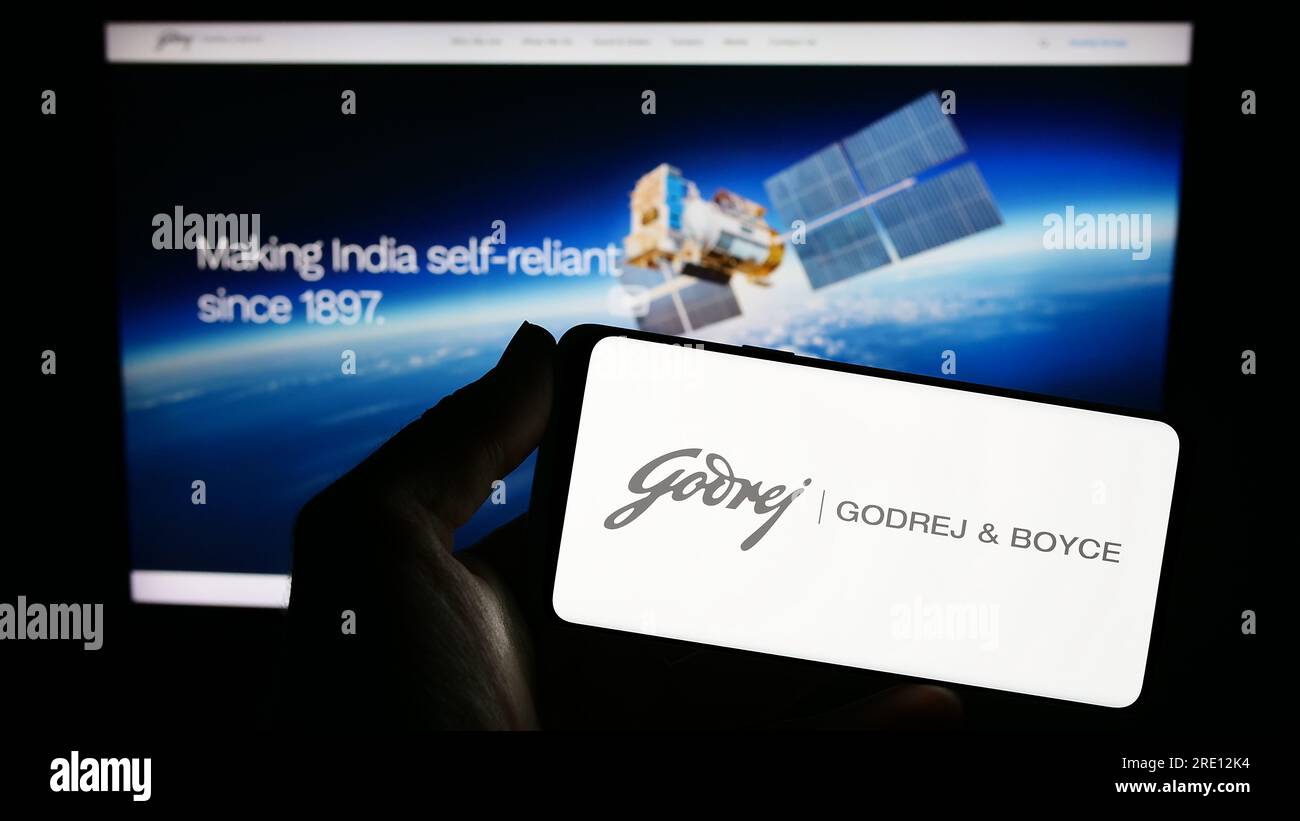 Person holding smartphone with logo of Indian company Godrej and Boyce ...