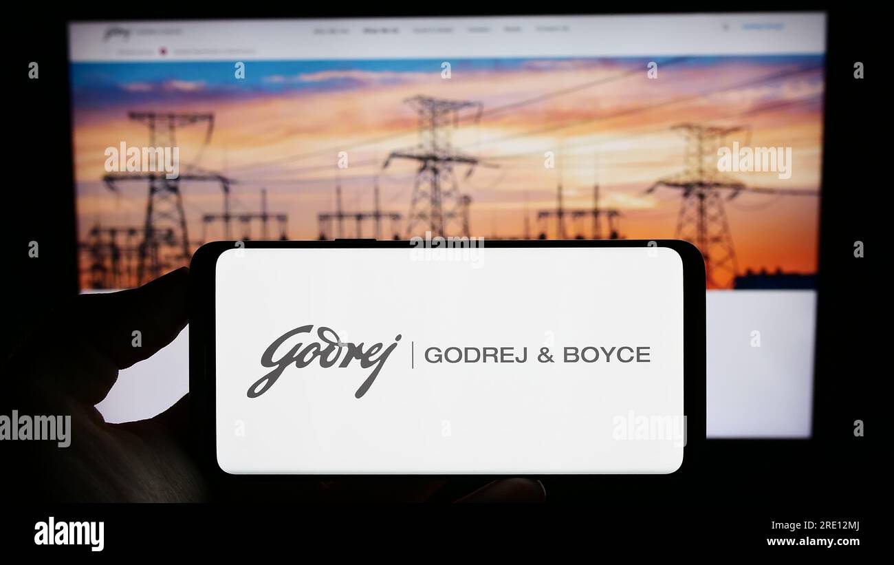 Person holding cellphone with logo of Indian company Godrej and Boyce ...