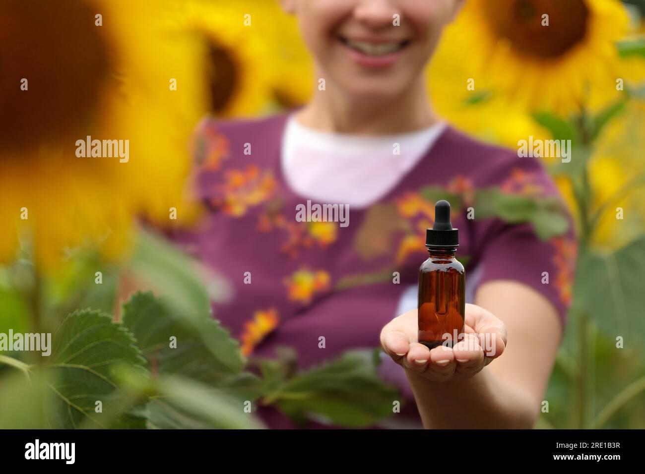 Smile woman holding a bottle of essential oil, blurred silhouette ...