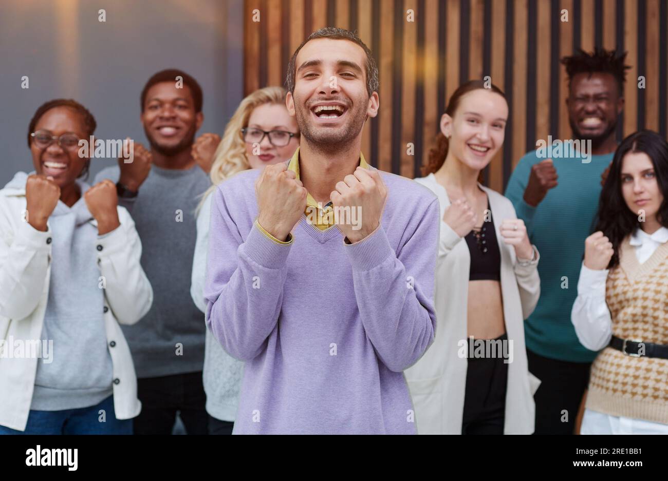 Happy people raise their hands up clenching their fists. Success ...