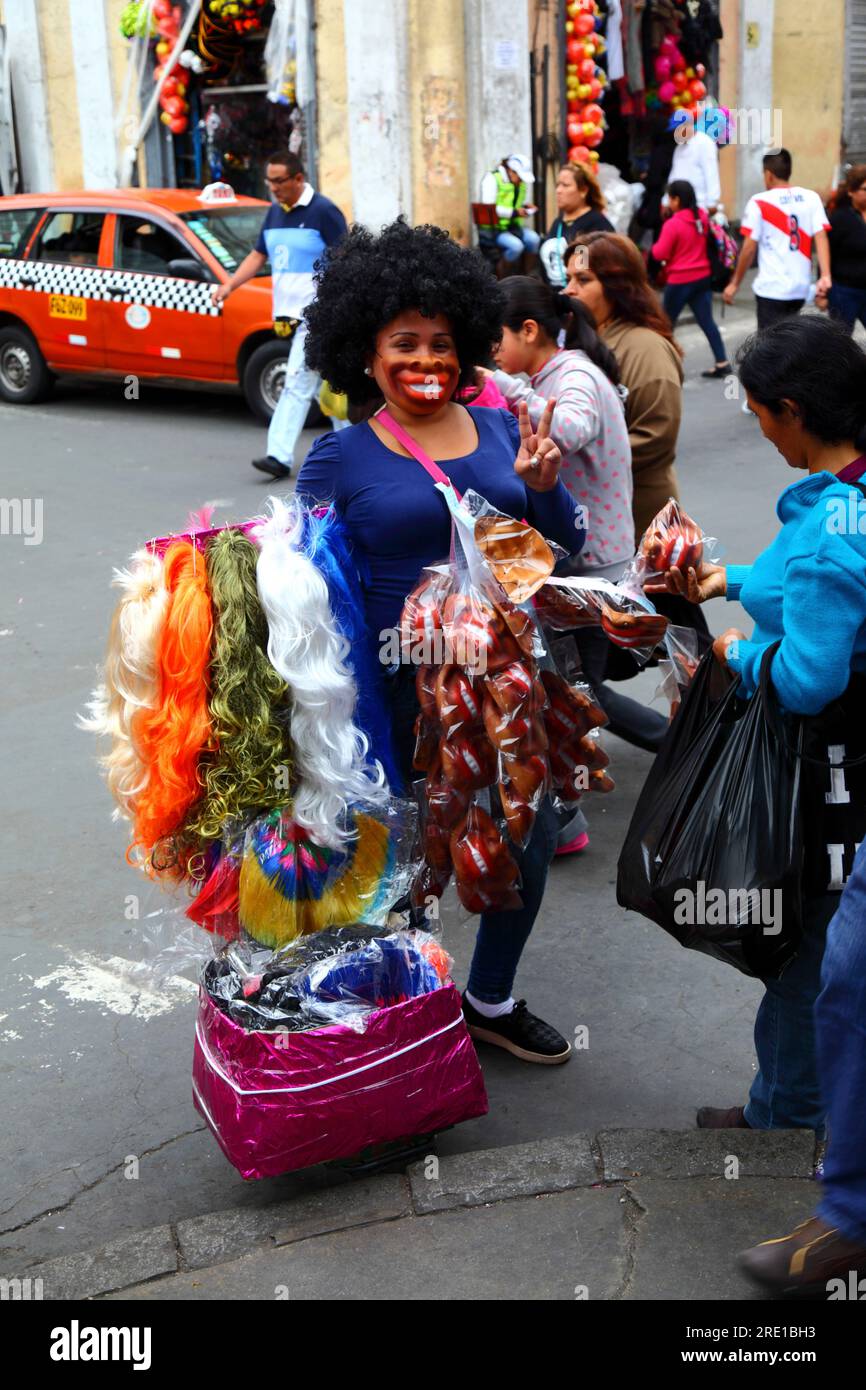 Woman wearing an afro wig and rubber face mask with big red lips ...