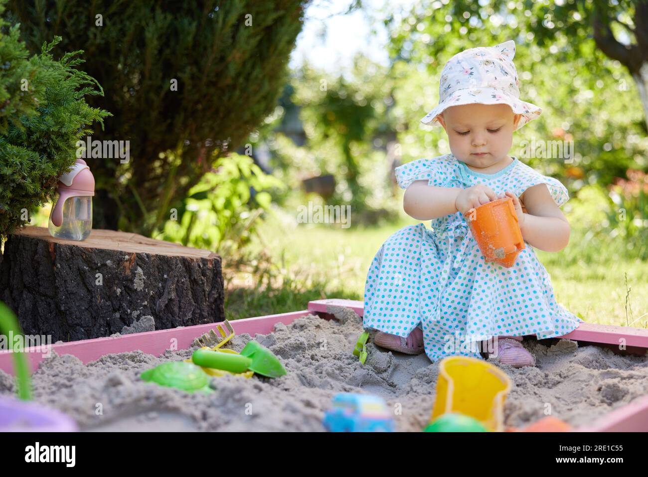baby girl playing in sand on outdoor playground Stock Photo - Alamy
