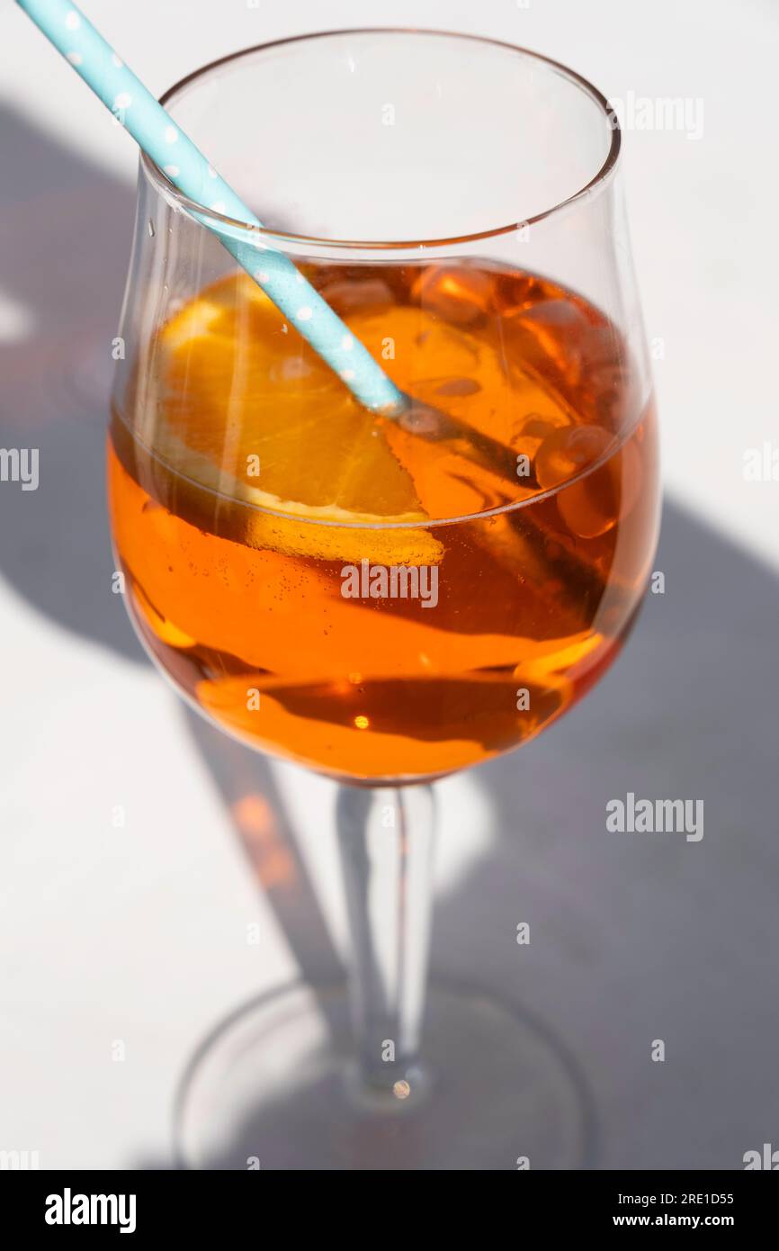Glass of cold Aperol Spritz with a cardboard straw in it, viewed ...