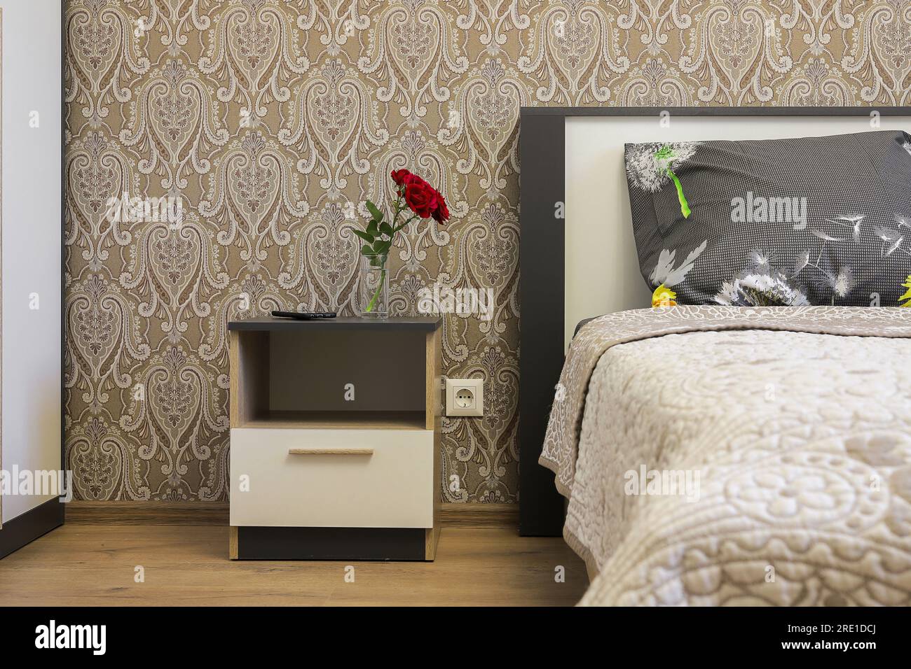 Flowers on the nightstand next to the bed in the bedroom interior Stock ...