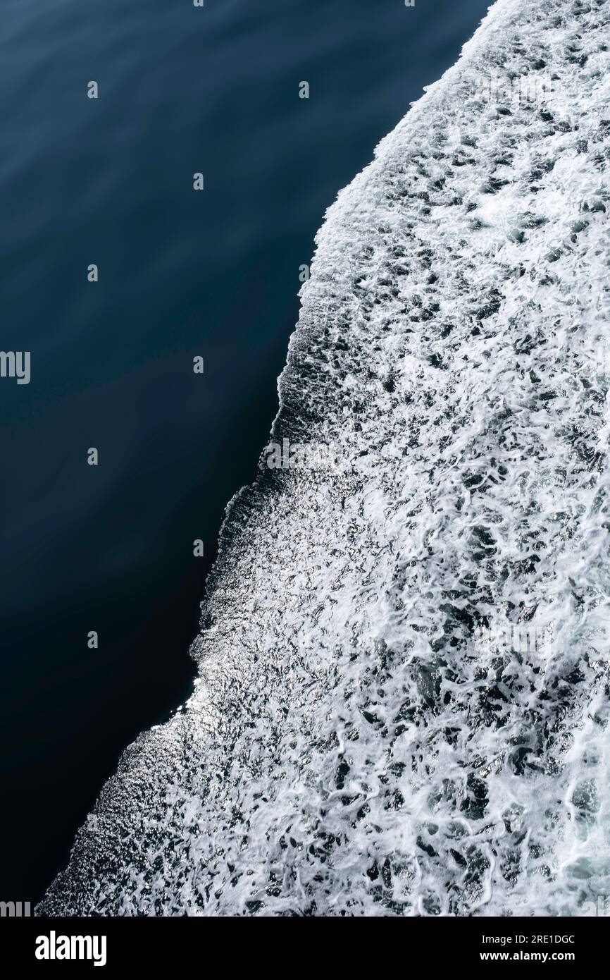 Bow waves of a ship with foam on the water of the blue sea. Aside ...