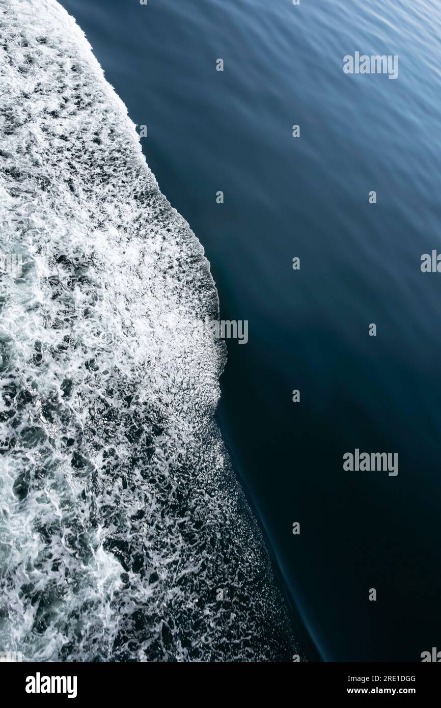 Bow waves of a ship with foam on the water of the blue sea. Aside ...