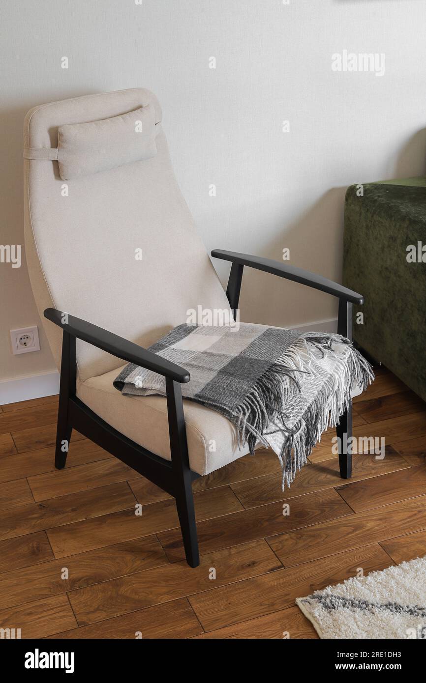 Cozy armchair with plaid in home interior Stock Photo - Alamy