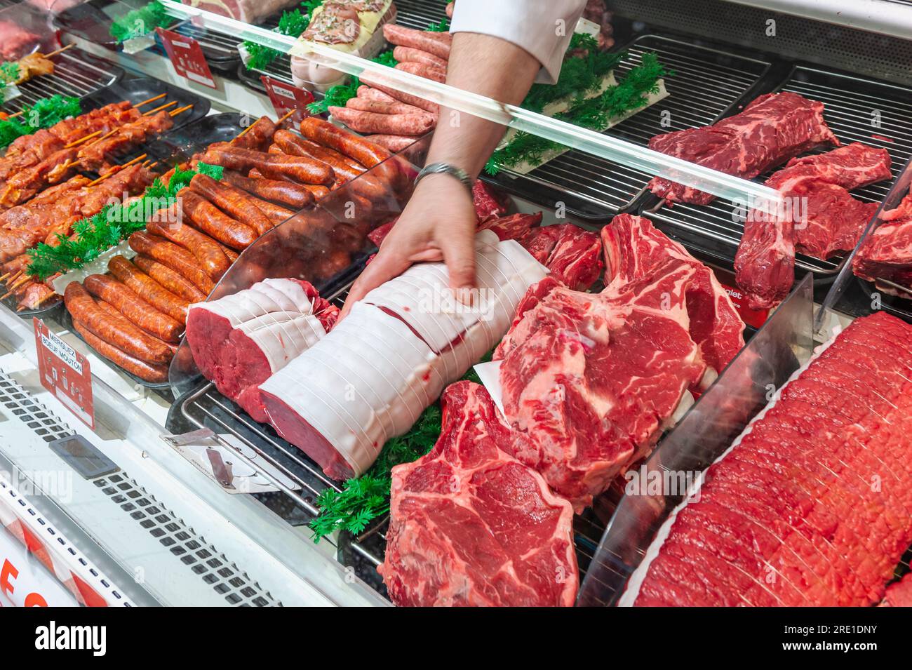 Butcher's in a supermarket. Butcher's taking a roast beef, meat for ...