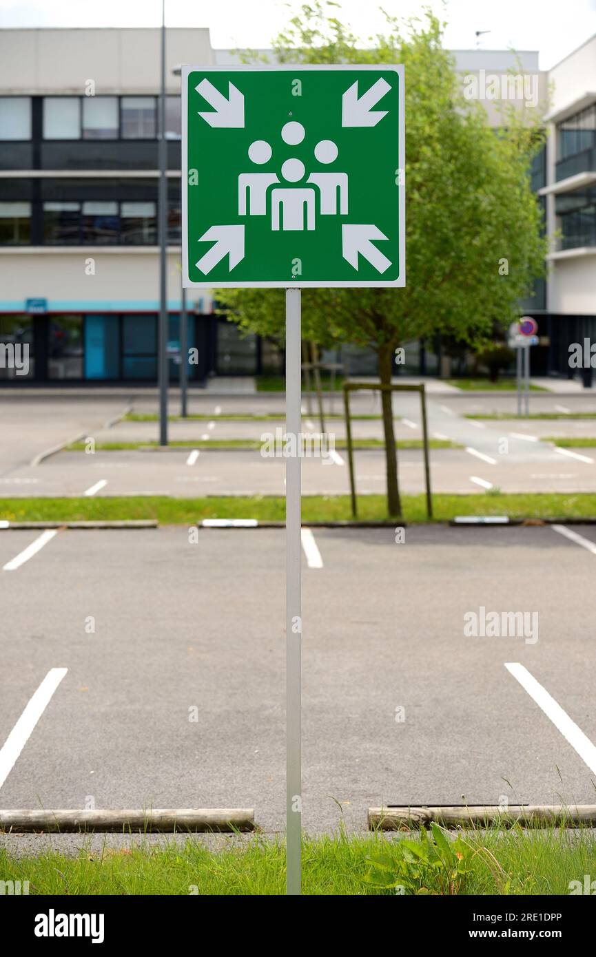 Assembly Point sign in a company parking lot, green sign with white ...