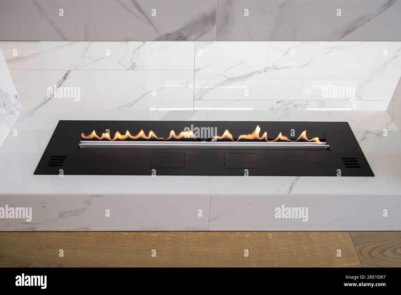 Burning modern eco bio ethanol fireplace built into white marble Stock ...