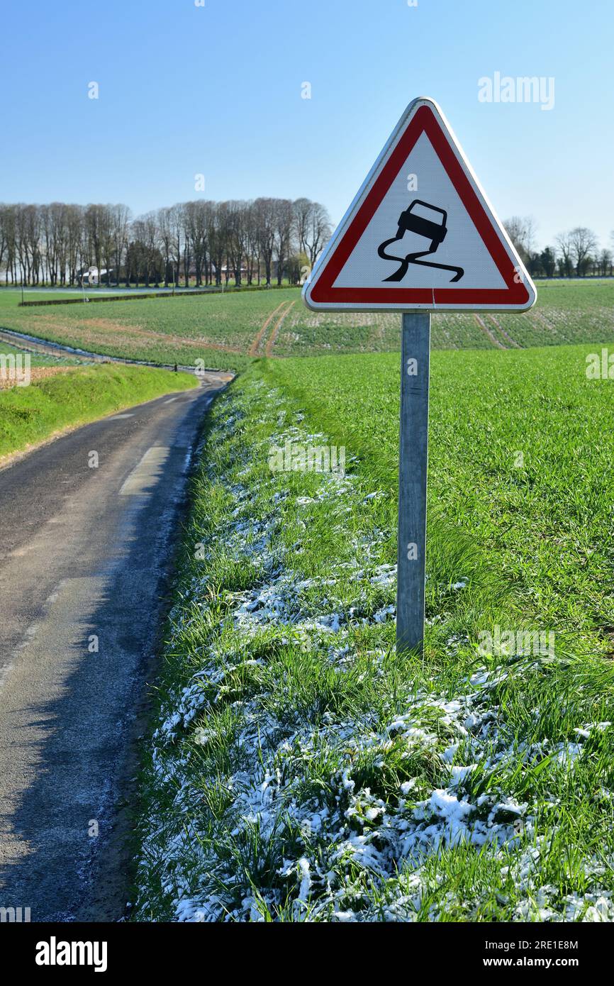 Slippery road sign by a country road in winter in La Rue Saint Pierre ...