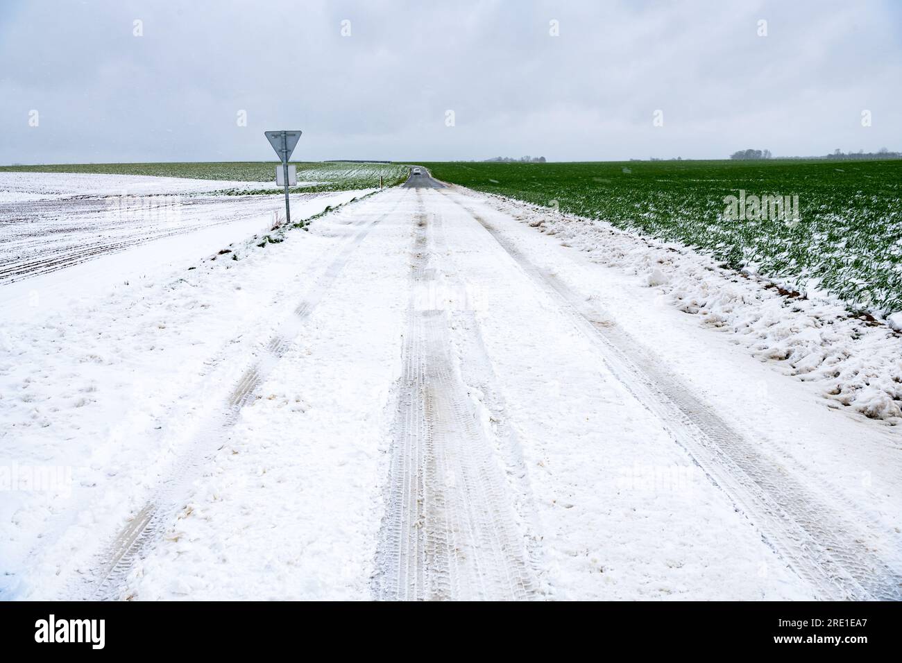 Snowy and icy country road, snowdrifts on the roadside and heavy ...