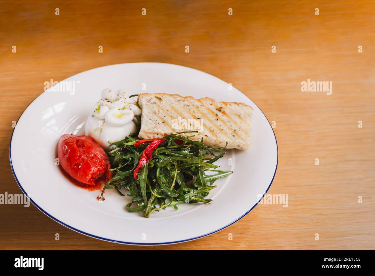 Rocket salad with Italian burrata cheese and tomato in white plate ...