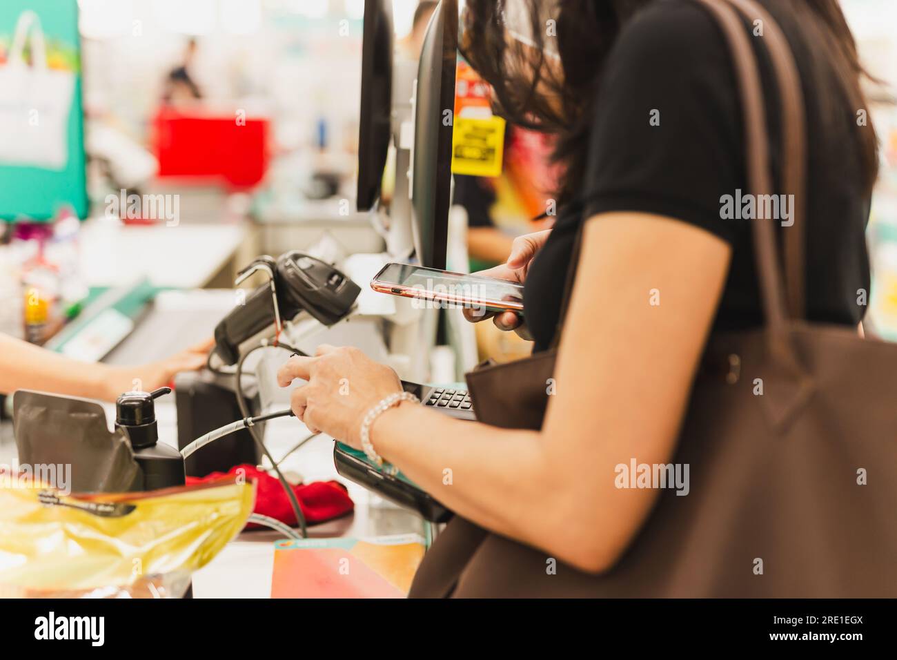 Woman customer scanning QR code payment via mobile phone at cashier ...