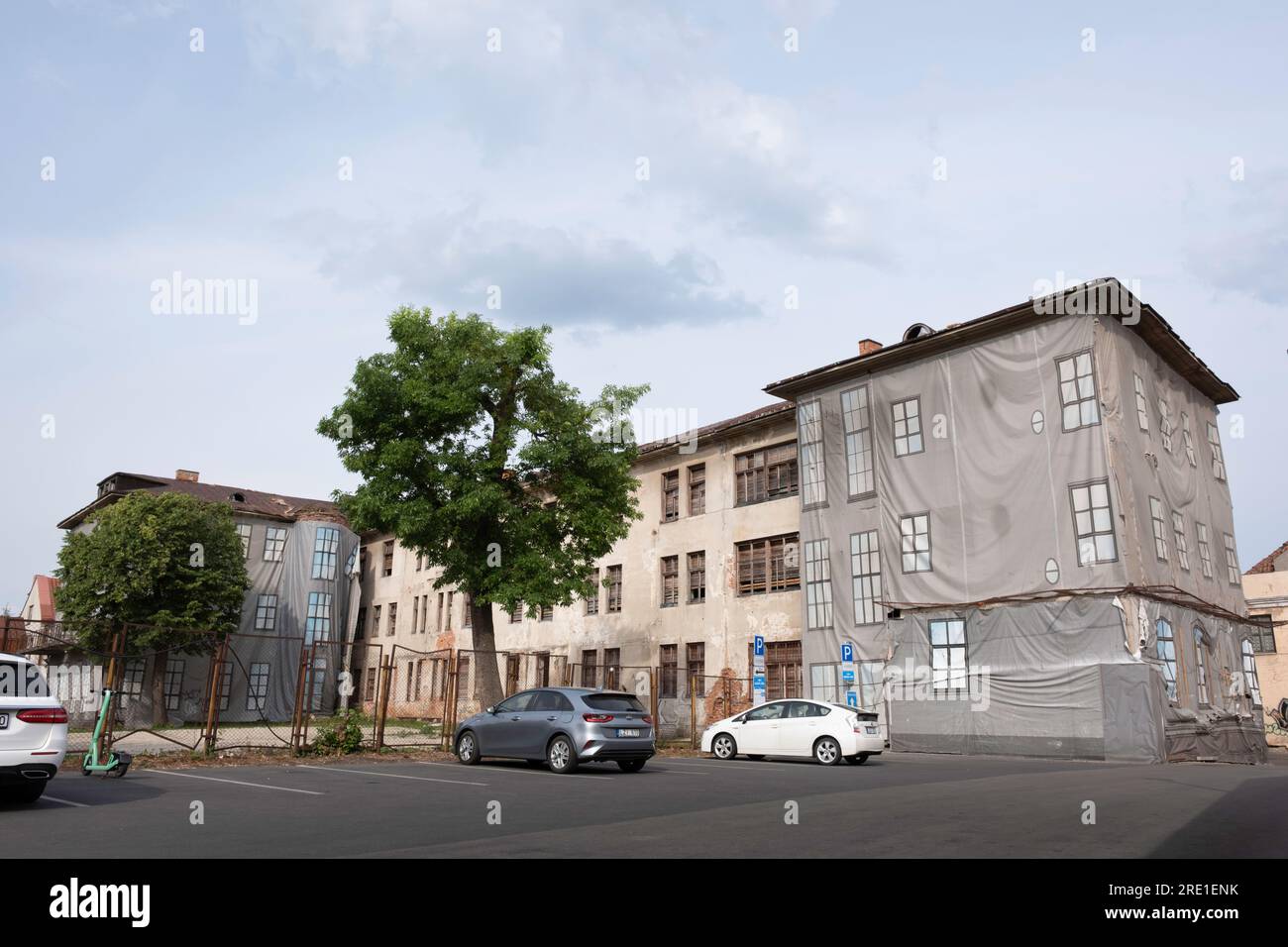 Derelict building wrapped in a window-painted canvas awaiting ...