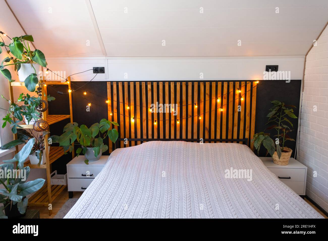 Loft style bedroom interior, black wall with wooden slats, metal bed ...