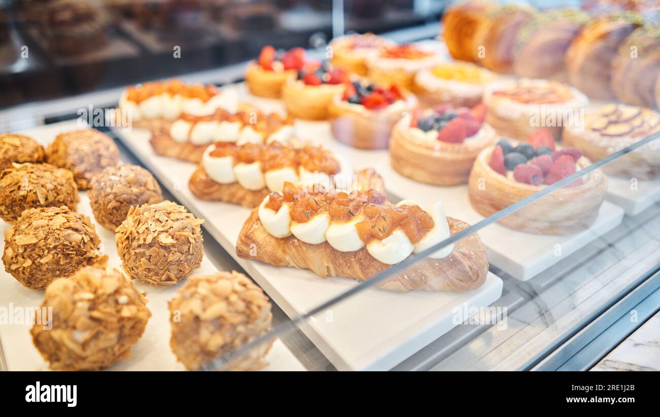 A variety of fresh pastries in the bakery window. almond croissant is ...
